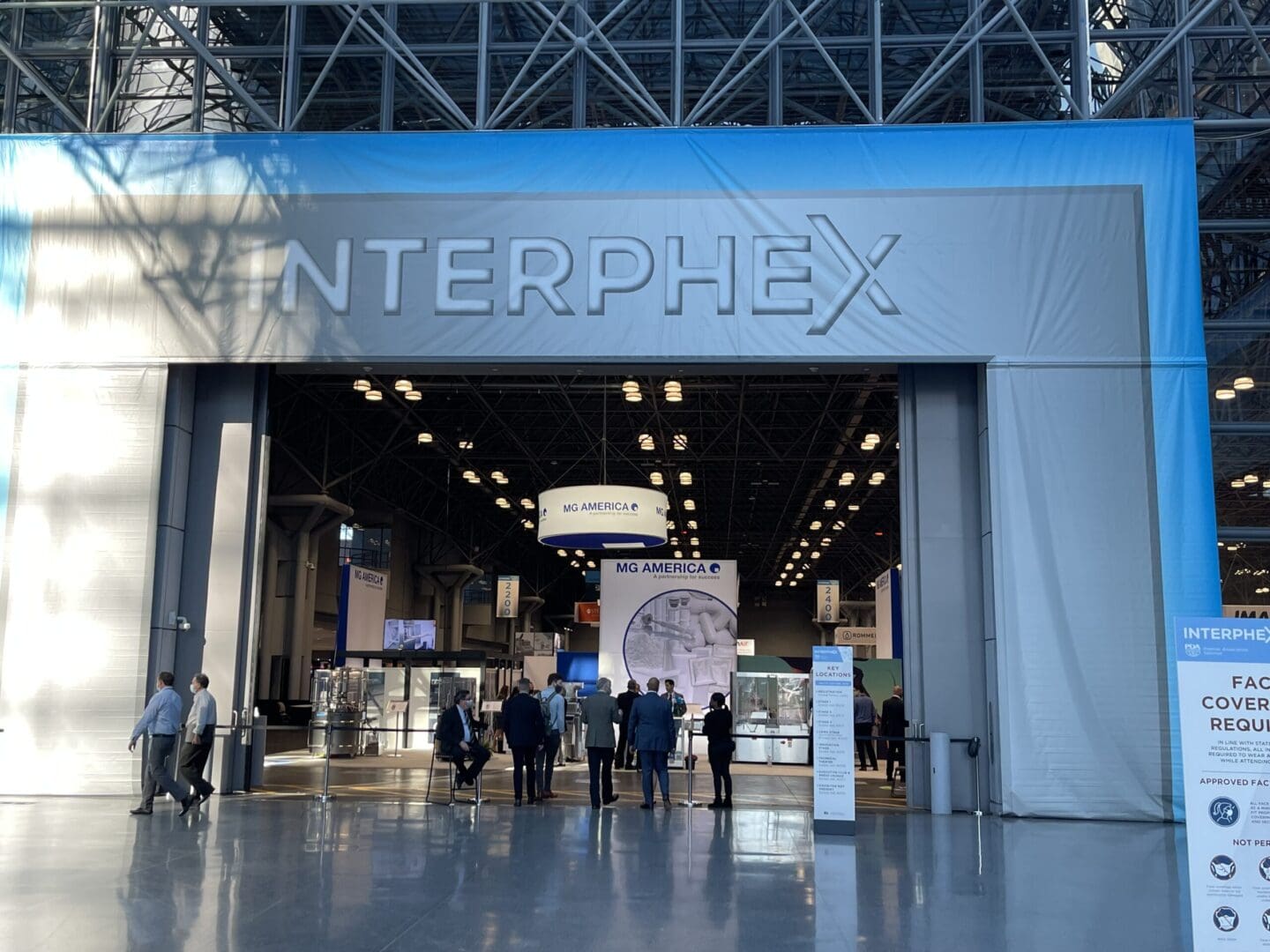 A group of people standing in front of an interpex booth. - New Jersey ...